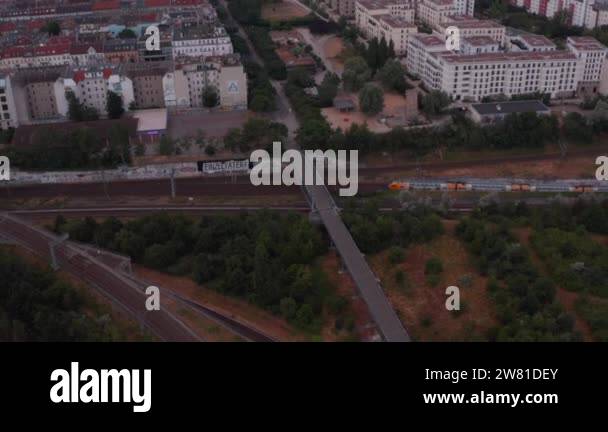 Backwards fly over railway track junction. Tilt up reveal of urban ...