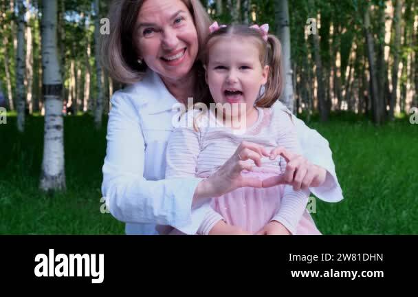 laughing grandmother and granddaughter, 3 years old, show the heart out ... laughing grandmother and granddaughter, 3 years old, show the heart out ...