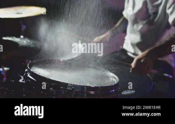 The drummer hits the wet drum cymbal with his drumstick and the water ...