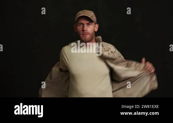 Strong serious military man take off his jacket in black studio Stock ...
