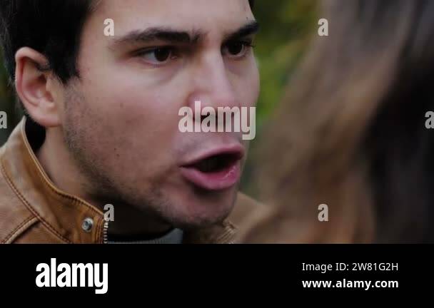 close up portrait of young angry man face to face with his girlfriend ...
