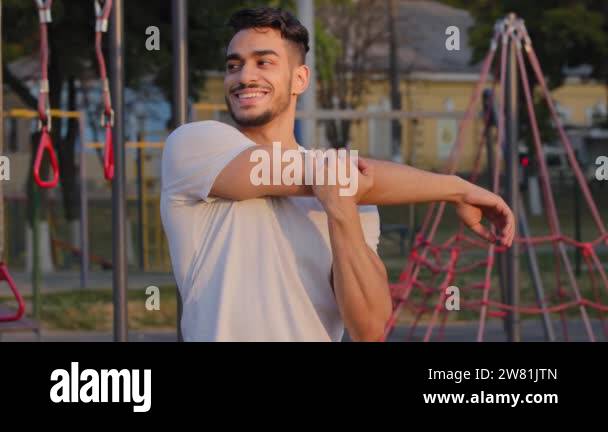 Young healthy sportive Middle Eastern Arab guy doing warm up in morning ...