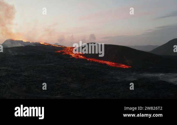 Fly above end of hot lava streams flowing from active volcano crater ...