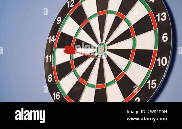 A game of darts. Throwing darts at the target. And someone will throw ...