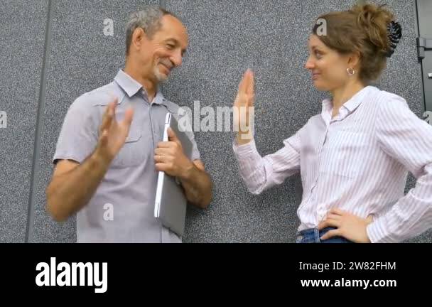 Two business people high-five each other celebrating the success of ...