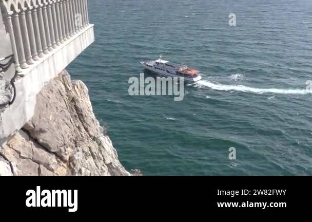A sea boat sails near the Swallow's Nest - a Gothic castle on a sea ...
