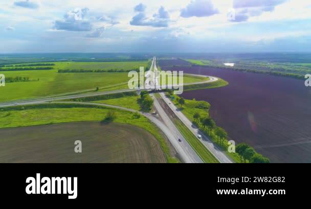 Big road with cars top view in good weather. Cars drive along the highway outside the city ...