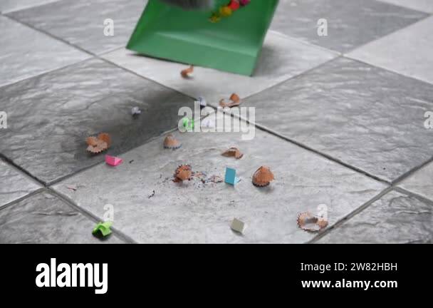 Sweep up scraps of paper and dust on tile floors with a broom and a ...