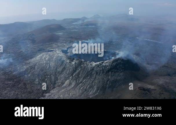Fly above volcano after eruption. Aerial view of top of mountain with ...