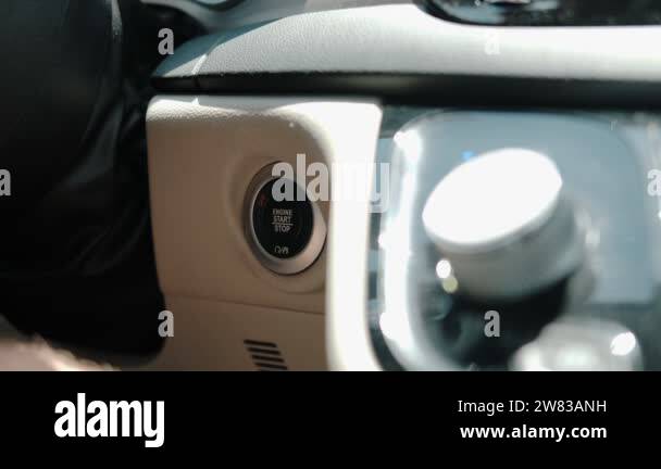 Driver man start engine in modern car, then shifts to neutral gear and ...