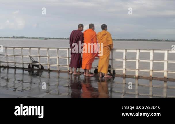 back view of three monks wearing red, orange and yellow robes on the ...