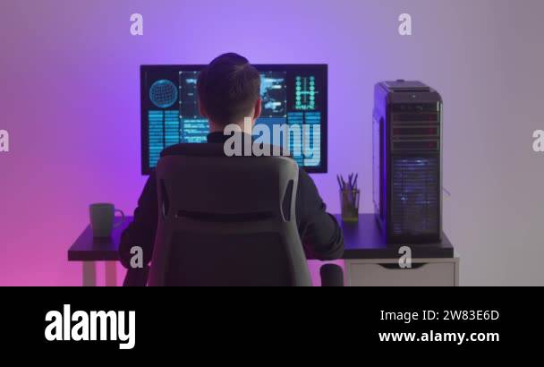 Rear view of man programmer working at computer, male hacker coding typing code on pc at office ...