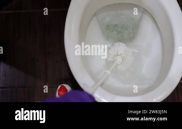 Toilet flushing, video 4K man cleans a toilet bowl using means for ...