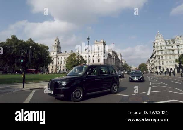 A traditional black cab coming to a stop at an intersection in ...
