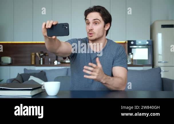 Handsome young guy man holding horizontally his smart phone in ...