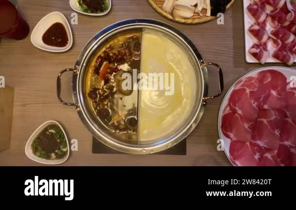 Traditional chinese hot pot style with a brass pot. Dining table, raw ...