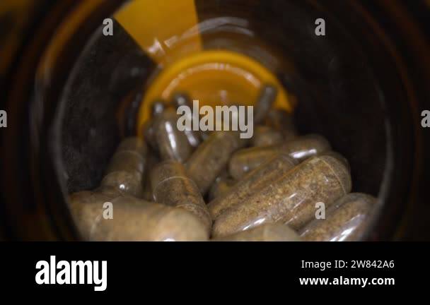 Natural herbal medicine capsules tablets, inside in a storage jar ...