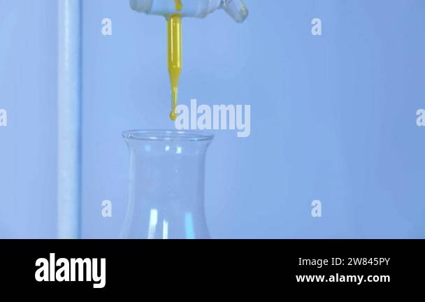 A scientist conducts an experiment in a laboratory and mixes chemicals ...