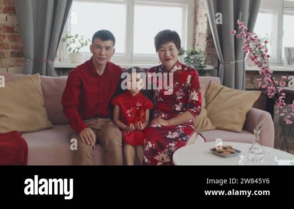 Portrait of Asian parents and 5-year-old girl wearing traditional ...