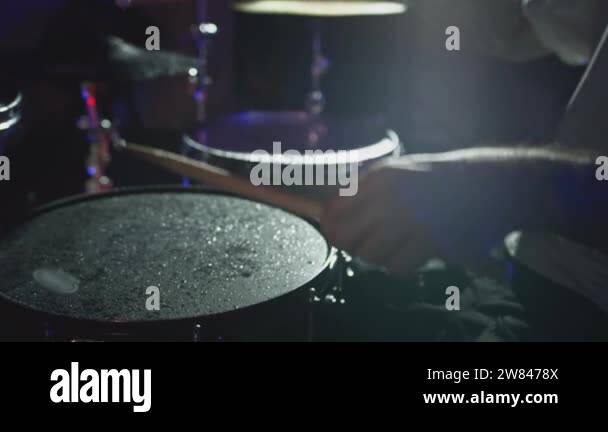 The drummer hits the wet drum cymbal with his drumstick and the water ...