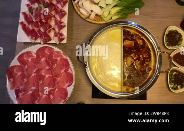 Traditional chinese hot pot style with a brass pot. Dining table, raw ...