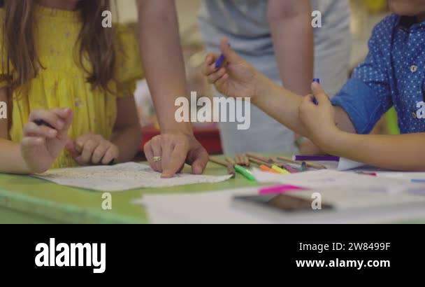 In primary school children drawing in the classroom with a female ...