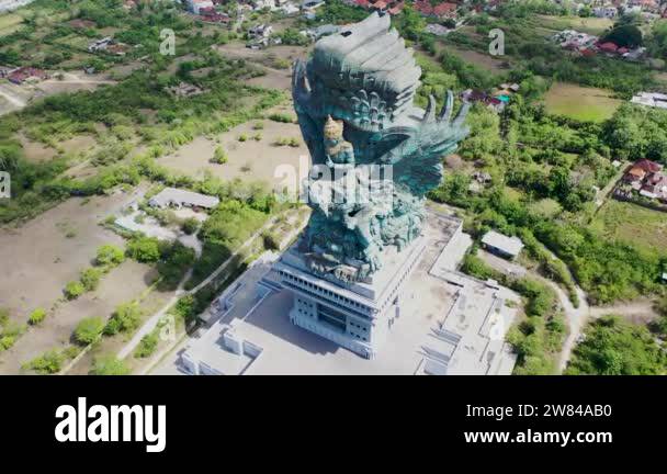 Front rotating aerial view of majestic copper and brass Garuda Wisnu Kencana statue in Bali ...