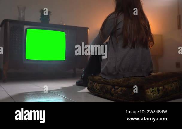 Old living room with dark lighting and green screen blinking vintage TV ...