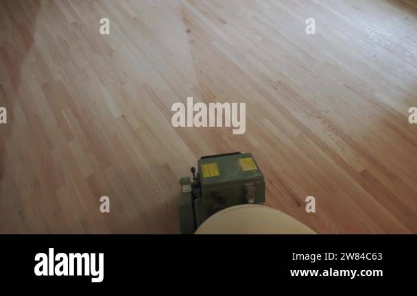 Man sanding a wood parquet with a parquet sanding machine. Top view ...