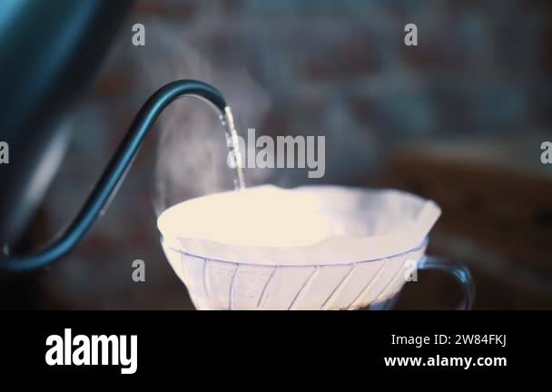 drip coffee brewing. close-up. barista pours boiling water from a ...