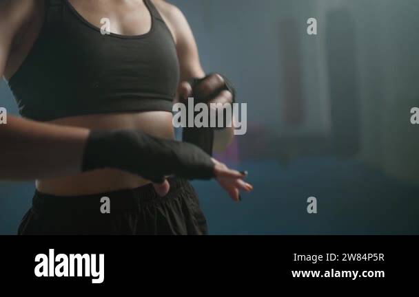 Woman fighter wraps her hands with boxing bandages, kickboxing training ...