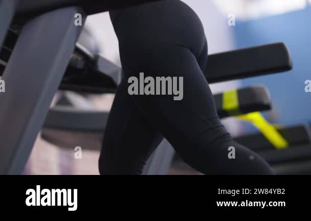 Fit slim buttocks of unrecognizable sportswoman jogging on treadmill in ...