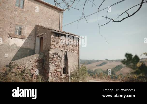Ancient stone houses with ruined rock walls on the side of lost road in ...