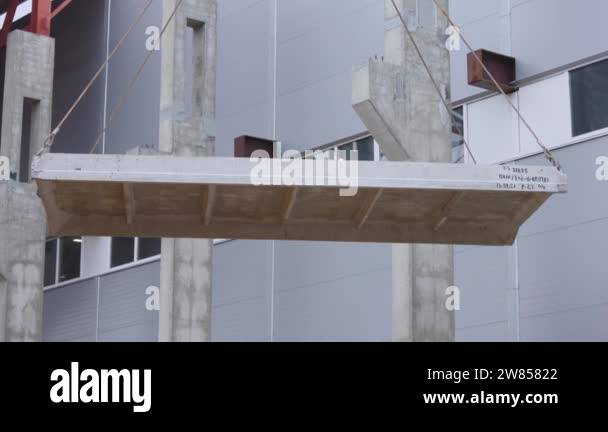 A crane lifts a reinforced concrete slab. Construction of a large ...
