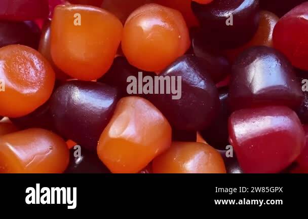 Close-up texture of red, orange and purple multivitamin gummies on ...