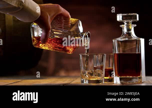 Detail of whisky bottle, pouring shot into glass, super slow motion ...