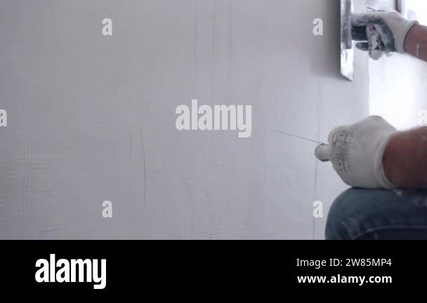 Workman reconstructing old ruined wall on construction site, builder ...