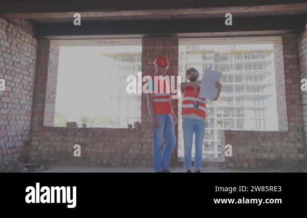 Builders inside a new building. Engineers with a blueprint inside a new ...