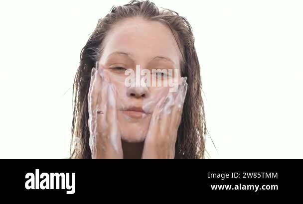 Portrait of young woman washing cleansing face with organic foamy ...