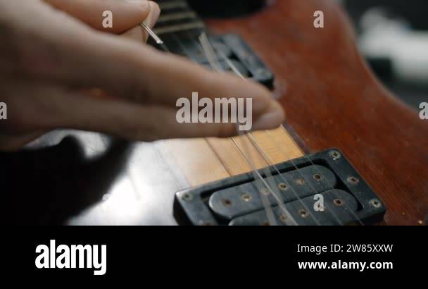 Guitar tech cuts the strings on the guitar by nippers in slow motion ...