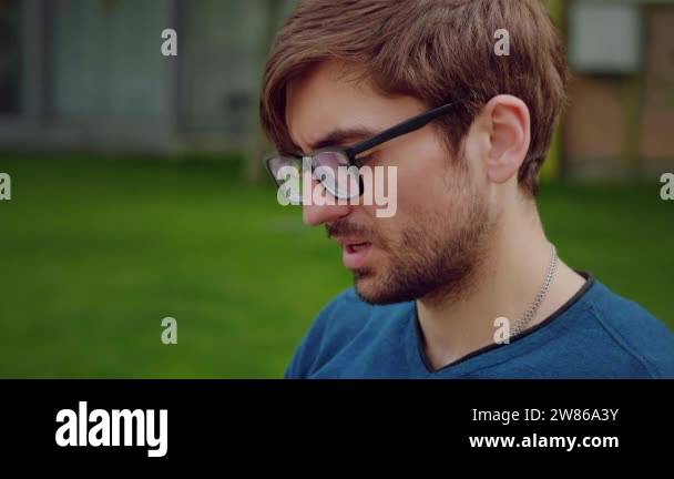 Man works on his laptop while sat on a bench outdoors slow motion ...