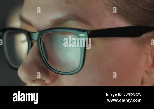 Woman in glasses looking on the monitor and and working with charts and ...