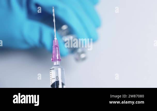 Close up shot of a transparent liquid vaccines being vertical pouring ...