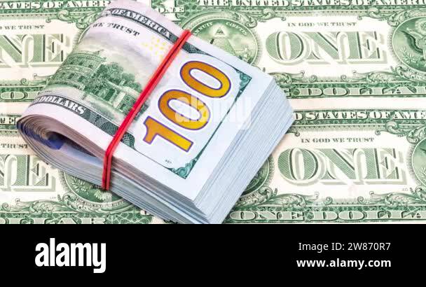 Folded american dollar bills wrapped by rubber band over dollars ...