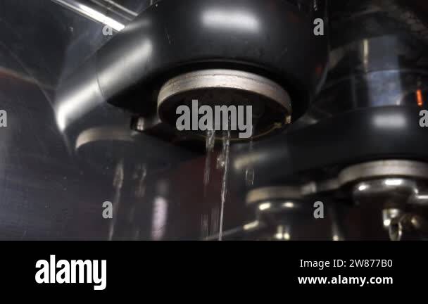 Boiling water pours out of the coffee maker with a sound. Steam appears ...