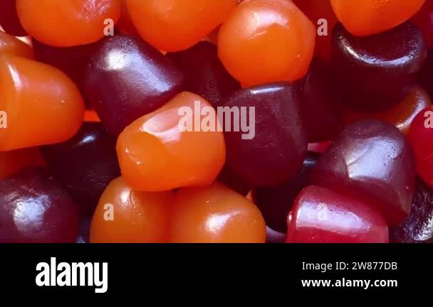 Close-up texture of red, orange and purple multivitamin gummies on ...