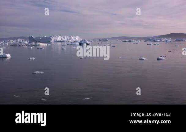 Arctic sailing among glaciers and floating ice blocks, in frozen sea ...