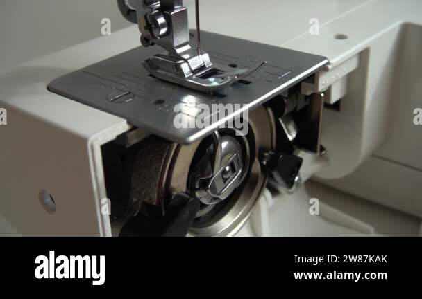 The needle of a sewing machine makes a thread stitch. Slow motion ...