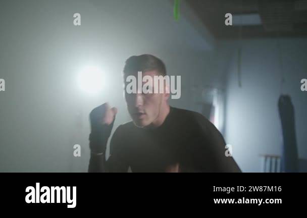 Man fighter trains his punches and defense in the boxing gym, a man ...