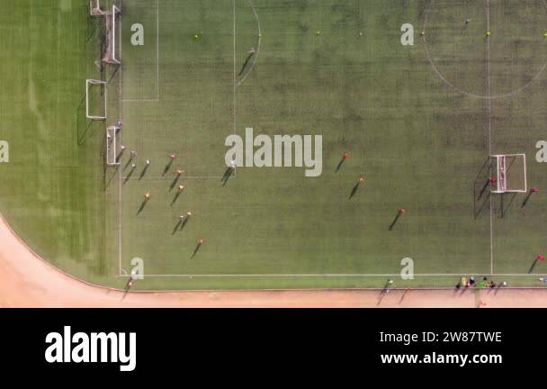 Top view of a drone taking aerial shots of kids playing soccer on a ...